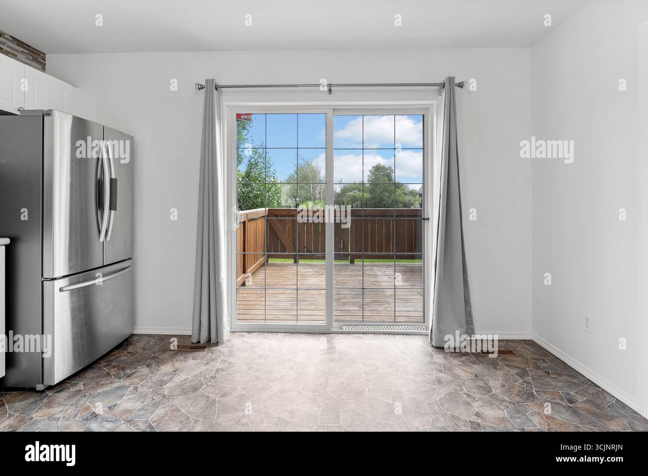 Kitchen with a silver refrigerator and a white door. The kitchen has a ...
