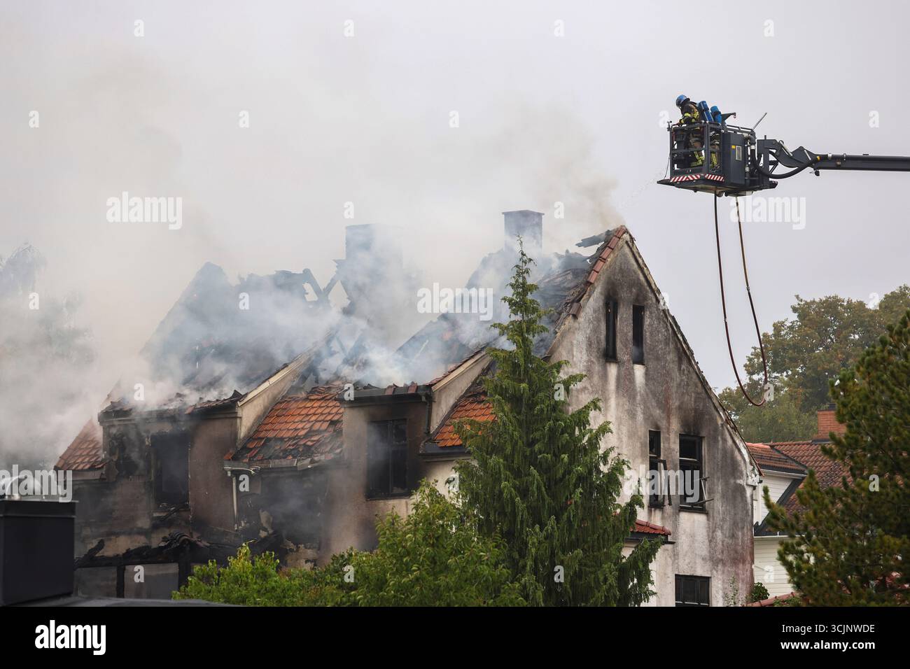 Firefighters extinguish a fire in a house, where four women aged 18-19 ...