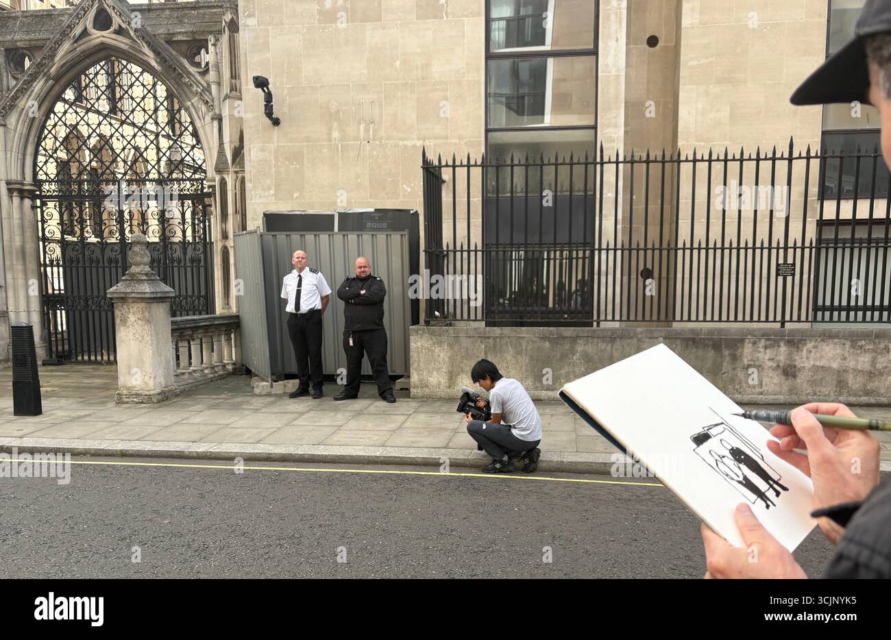 An artist draws the scene, where two security guards are standing next ...