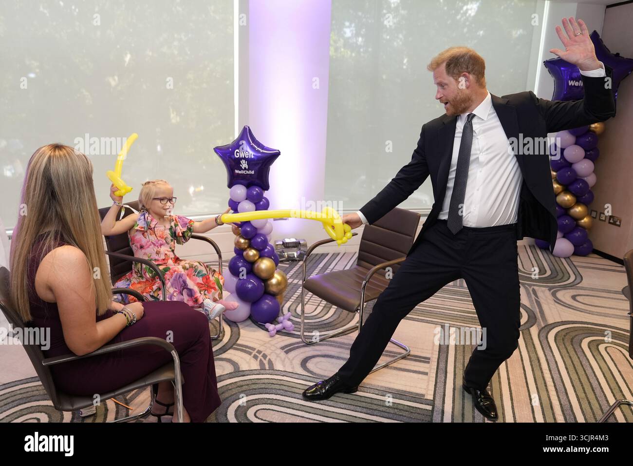 Britain's Prince Harry plays with nine-year-old Gwen Foster, recipient ...