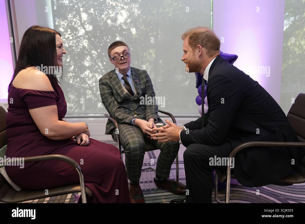 Britain's Prince Harry speaks with Declan Bitmead, center, recipient of ...