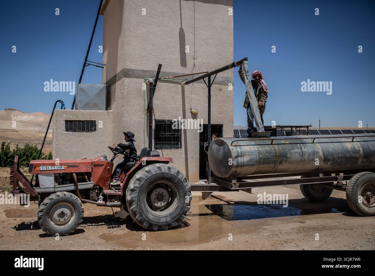 A man and boy prepare to irrigate roses in Qaldoun Al Marah, Syria - a ...