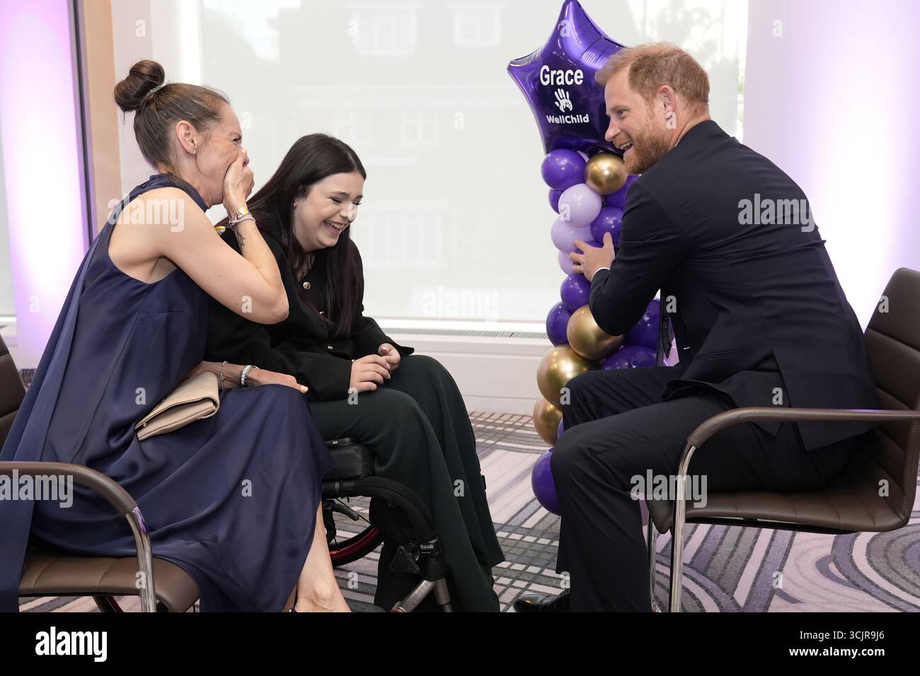 Britain's Prince Harry speaks with Declan Bitmead, center, recipient of ...
