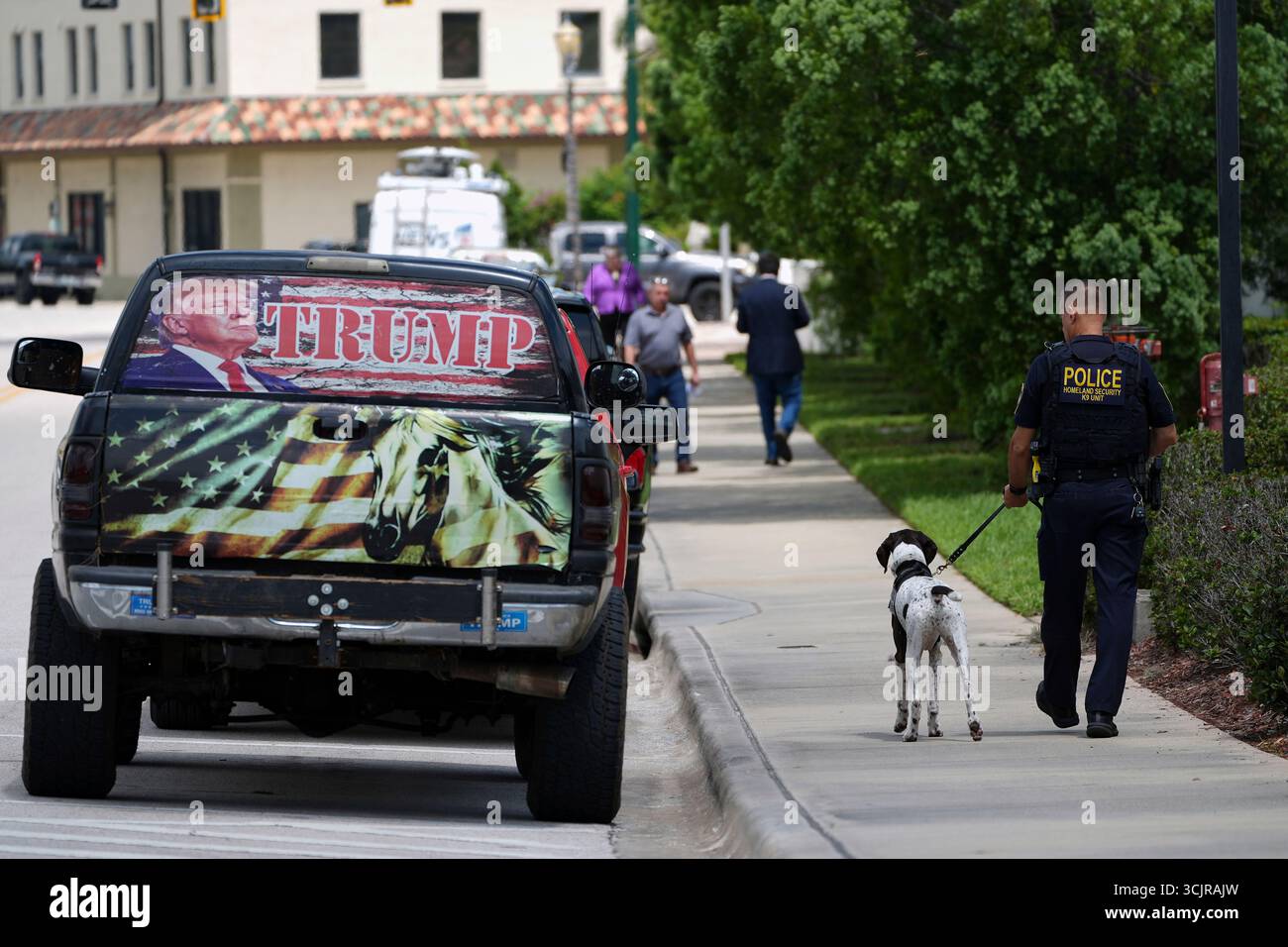 A Department of Homeland Security K9 unit officer walks past a truck ...