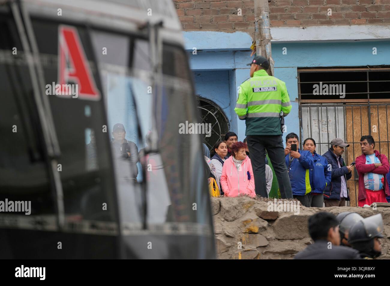 Residents look at the crime scene where bus driver Arturo Ramon was ...