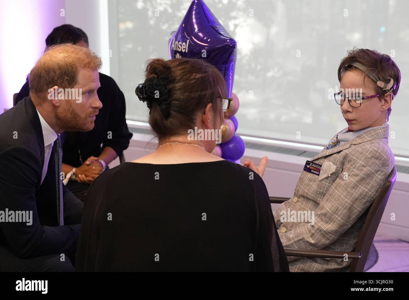 Britain's Prince Harry speaks with 13-year-old Ansel Hayward, recipient ...