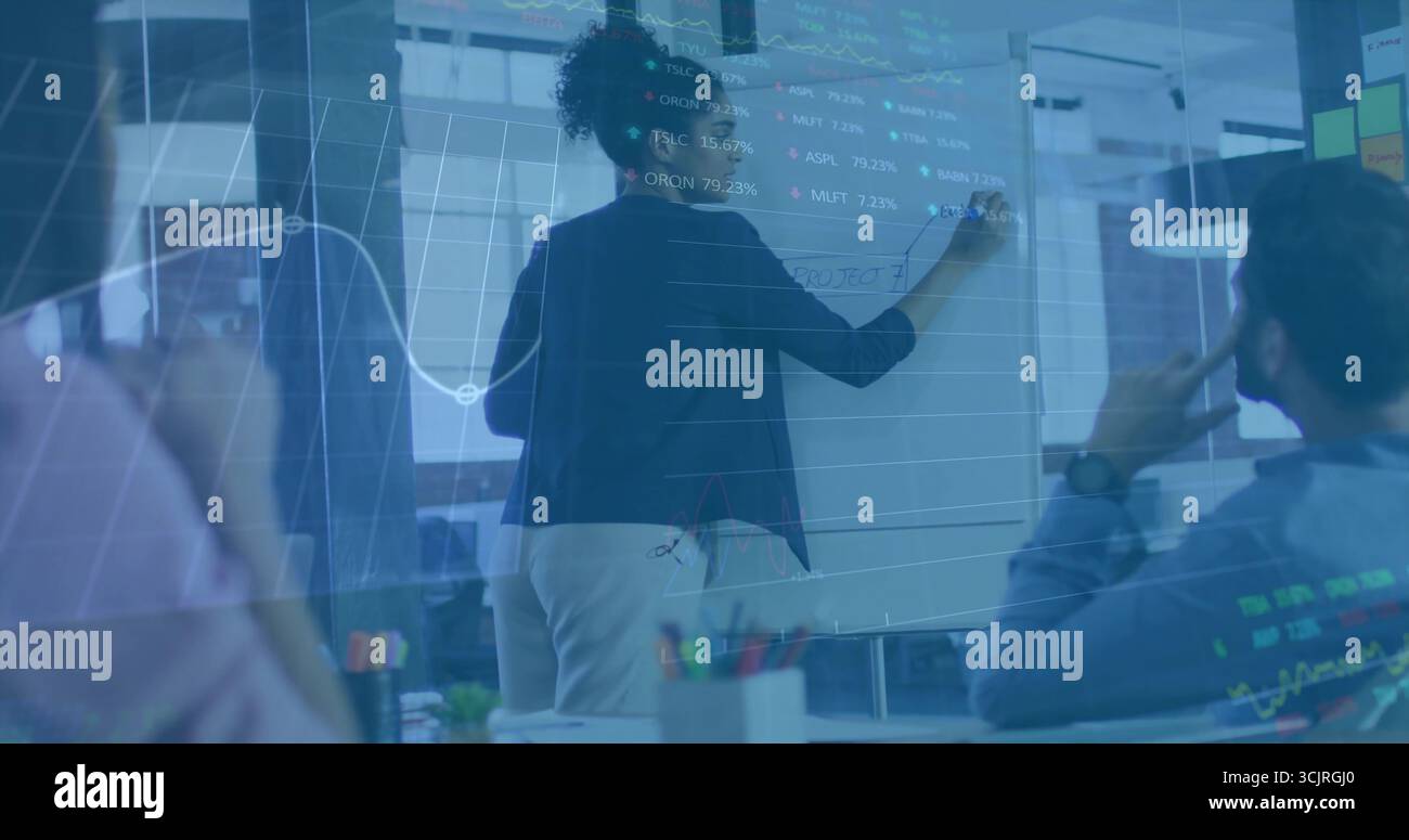 Woman wearing dark blazer marking data on whiteboard in conference room ...