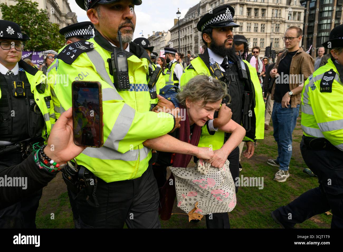 Police carrying an arrested protester out of Parliament Square in ...