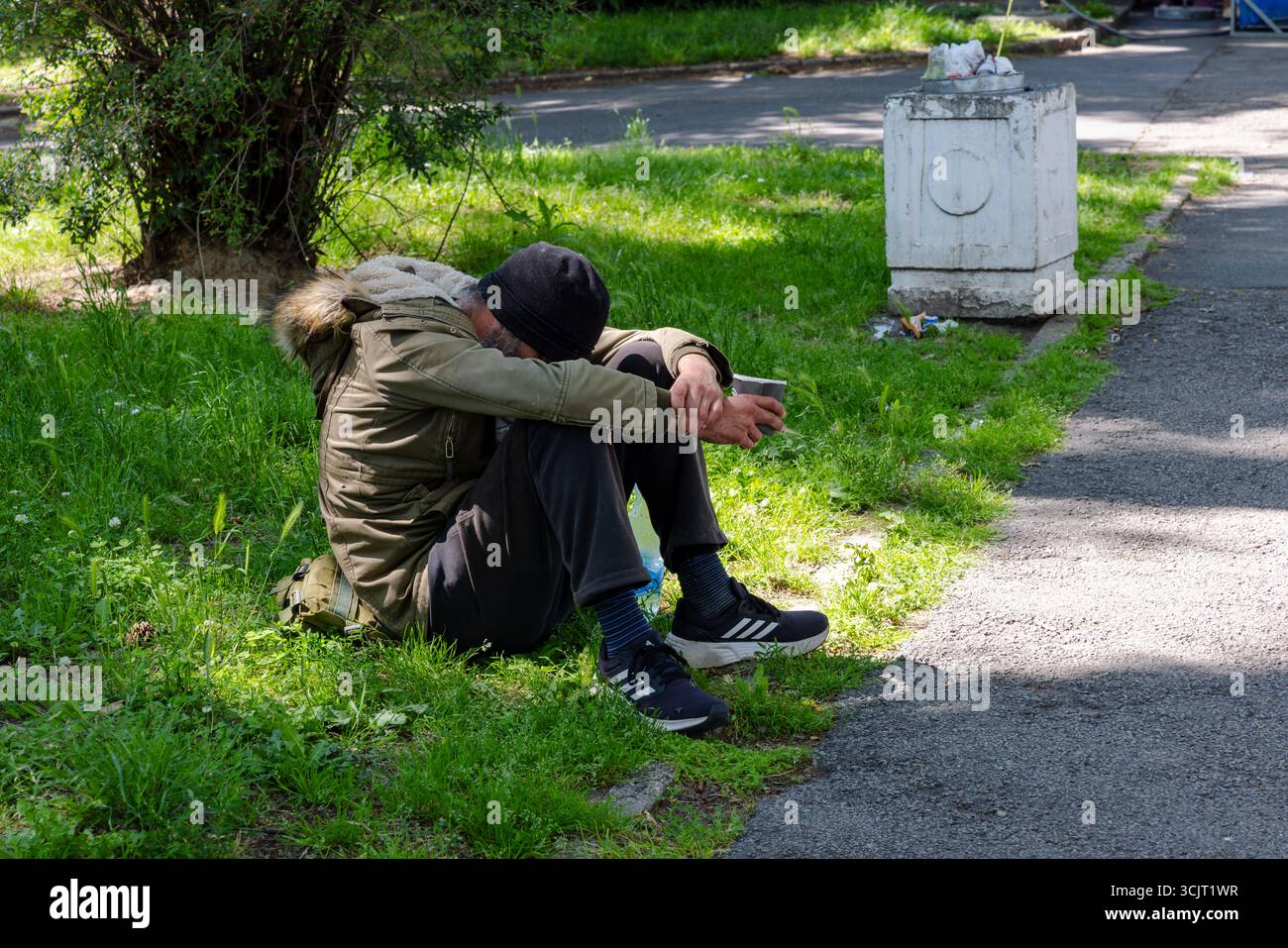 Sad beggar sitting head down hi-res stock photography and images - Alamy
