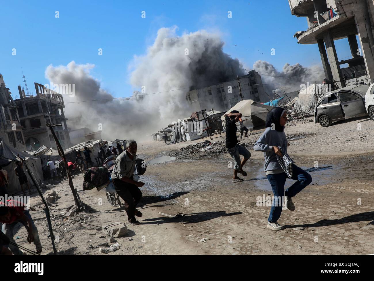 Gaza. 8th Sep, 2025. Palestinians run to escape the smoke raised from ...