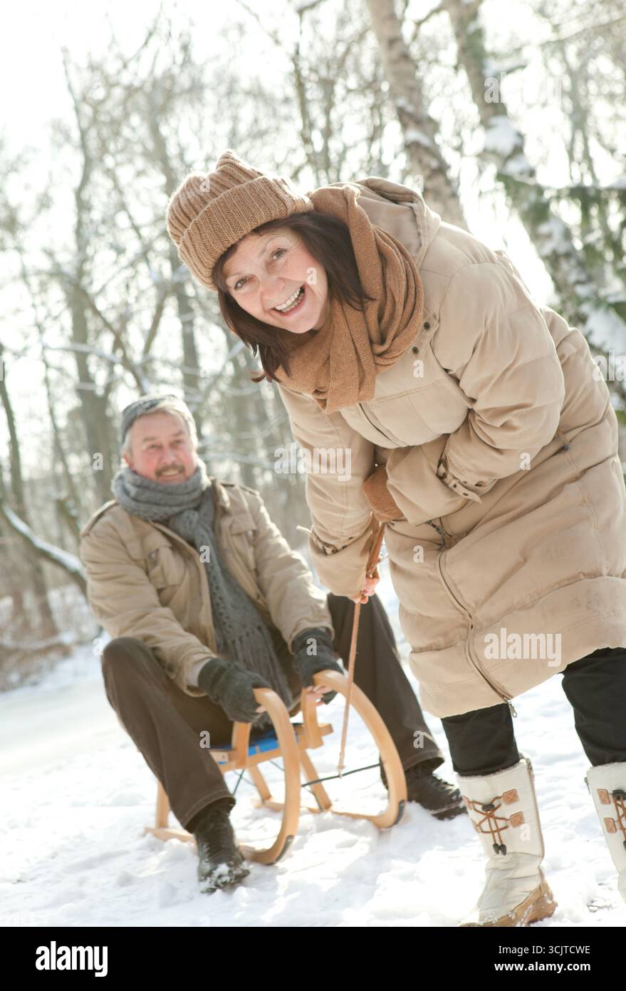 cheerful pensioner pulling pensioner on a sleigh Stock Photo - Alamy