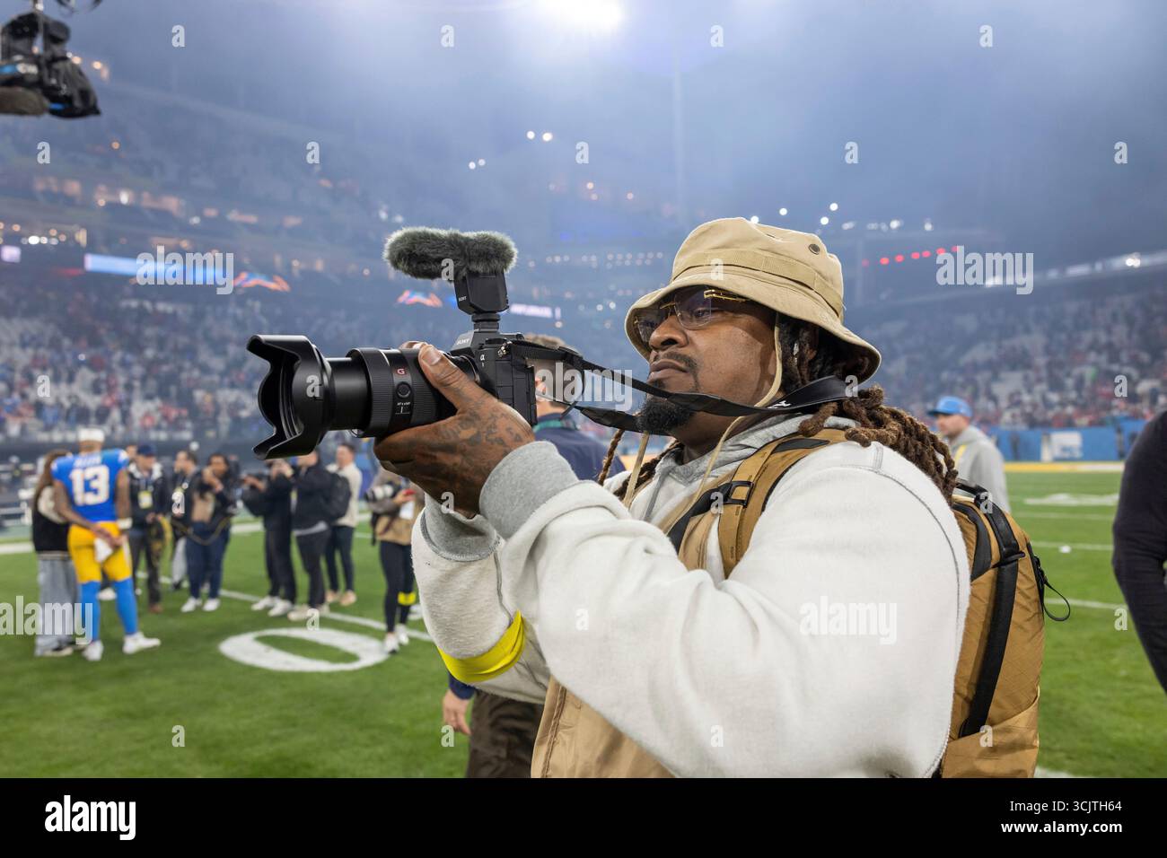 NFL Legend Marshawn Lynch photographs player as they walk off the field ...