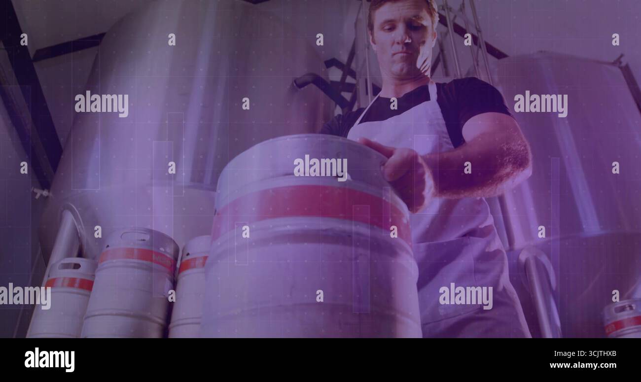 Brewery worker wearing white apron lifting keg on brewery floor, with ...