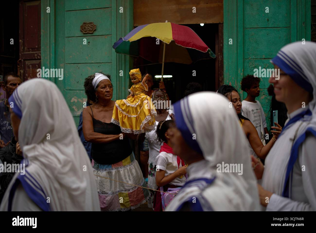 Faithful watch a procession honoring the Virgin of Charity of Cobre, on ...