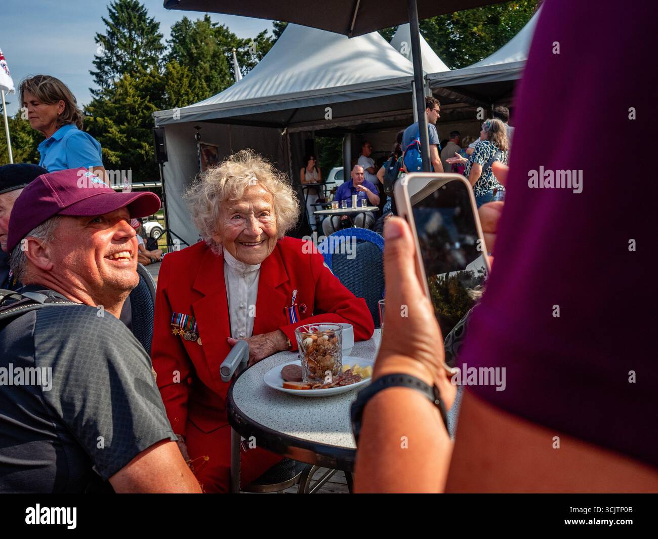 WWII veteran Robbie Hall takes a photo with one of the walkers. This ...