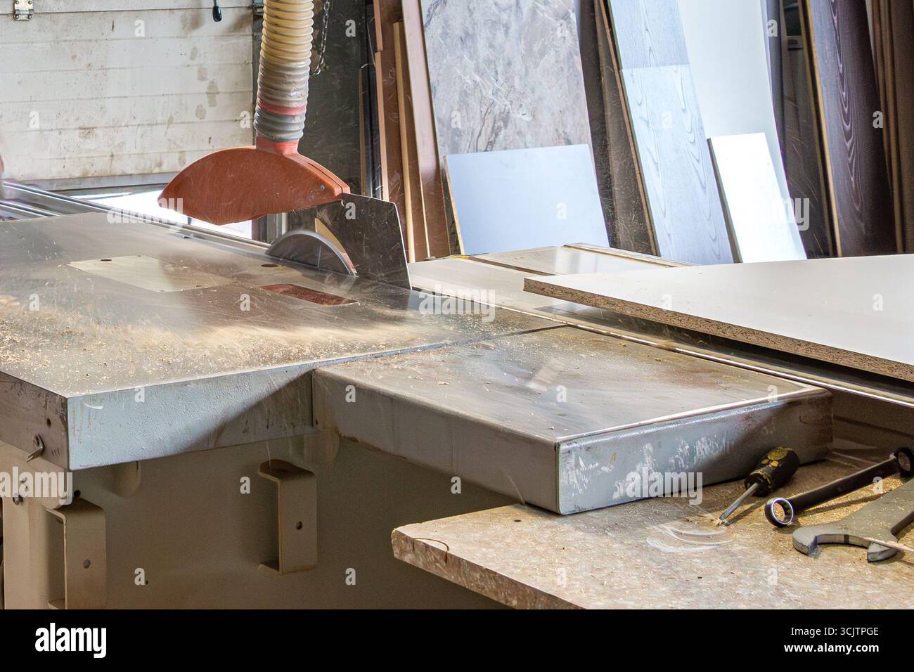 Worker operates a table saw to cut wooden panels with precision, with ...