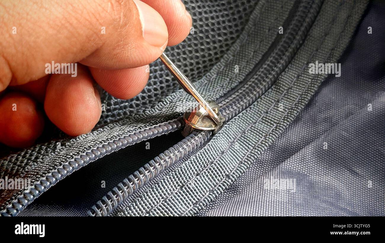 Person's Hand Aligning a Zipper on a Backpack Stock Photo - Alamy