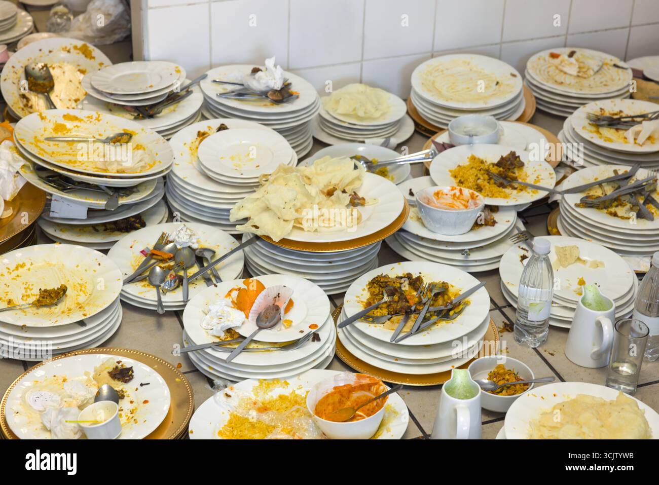 Pile of dirty plates and cutlery chaos with leftovers on the Kitchen ...