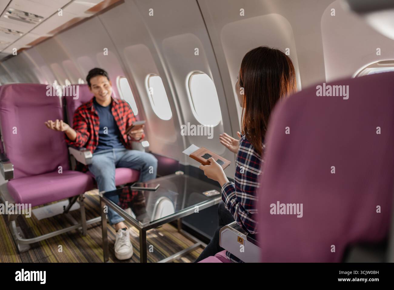 Young couple chatting happily while seated across from each other on a ...