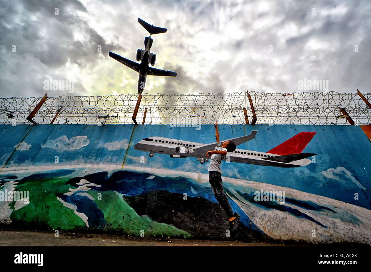 Mumbai, India. 07th Sep, 2025. A child jumps while a jet flies cross ...