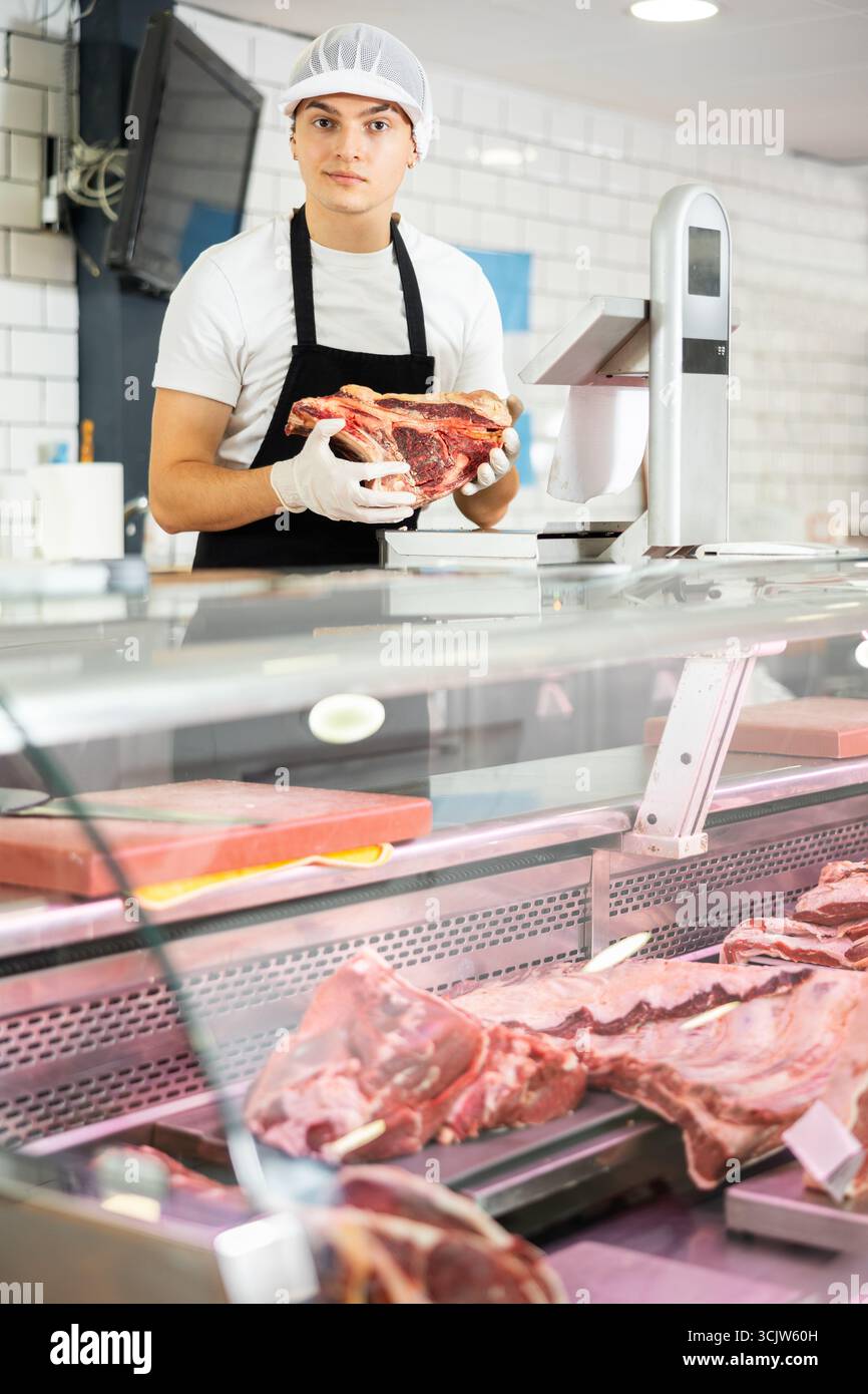 Guy seller works in specialized butcher shop Stock Photo - Alamy