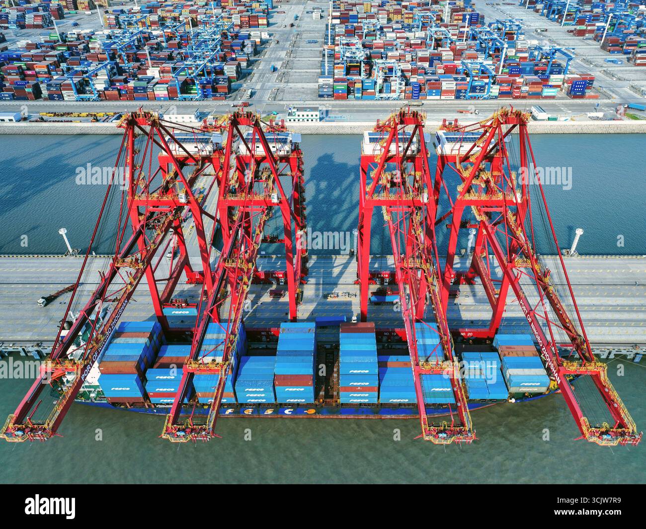 A cargo ship is loading and unloading containers in an orderly manner ...