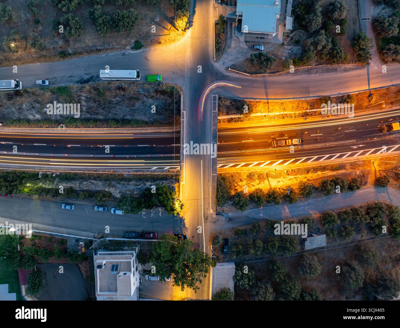 Aerial view of illuminated roads and a bridge cutting through the night ...
