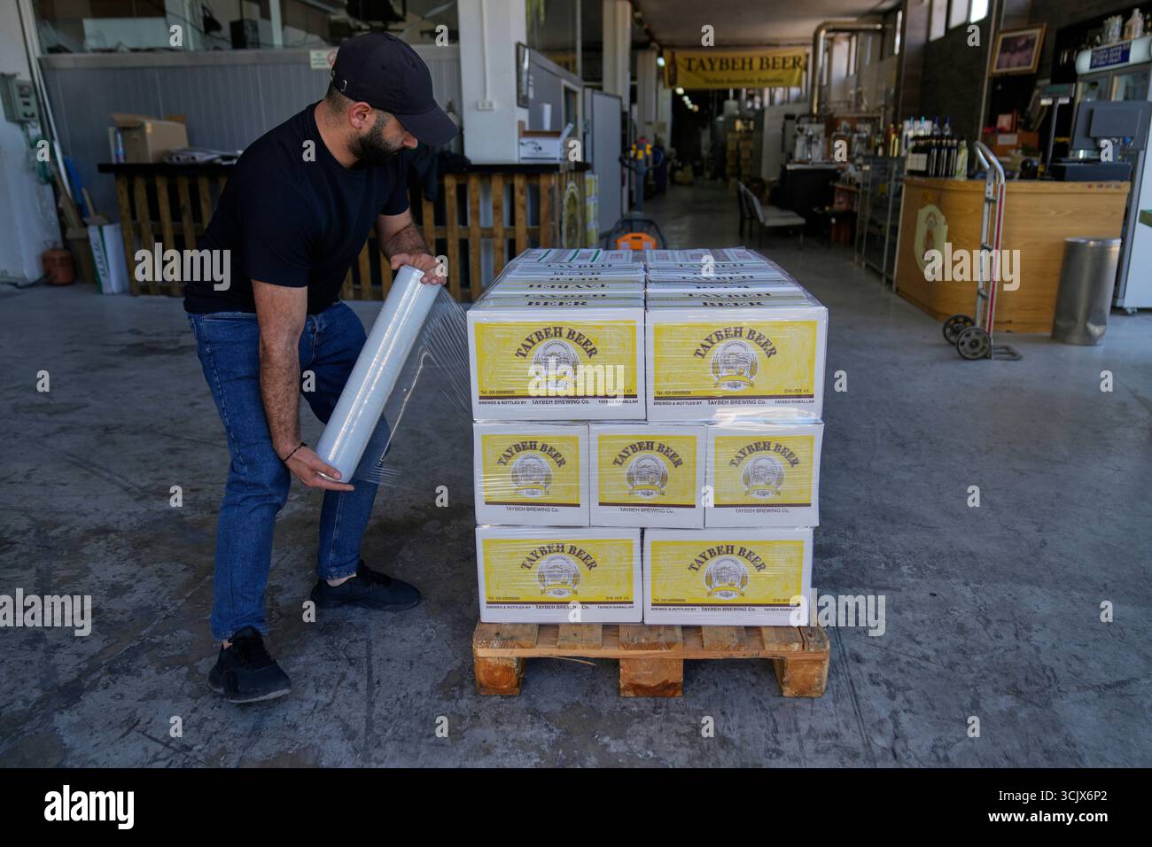 A worker prepares a shipment of Taybeh beer products at the Palestinian ...