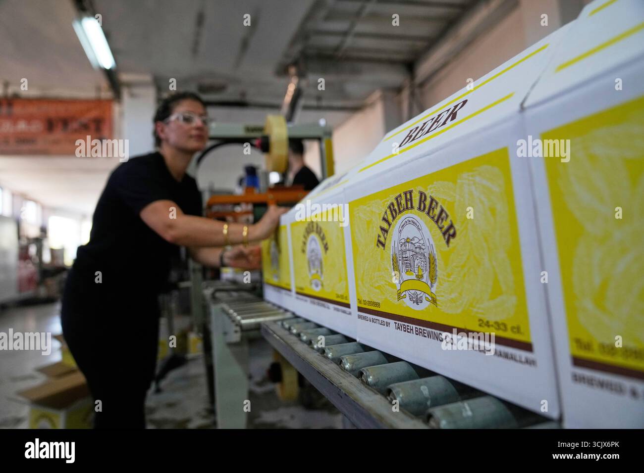 Nadin Khoury, 36, packs Taybeh beer products on a production line of ...