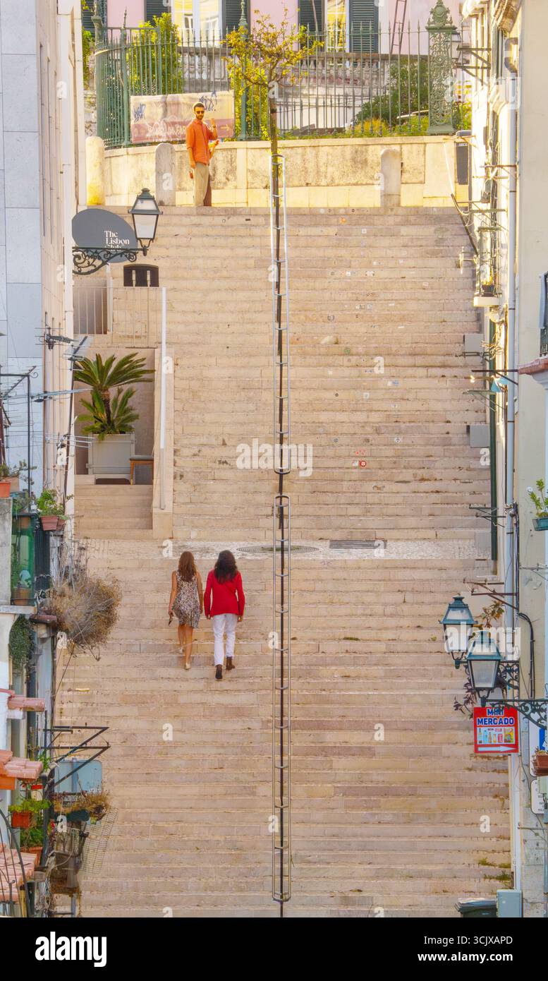 Two women walking up steep limestone steps in historic Bica ...