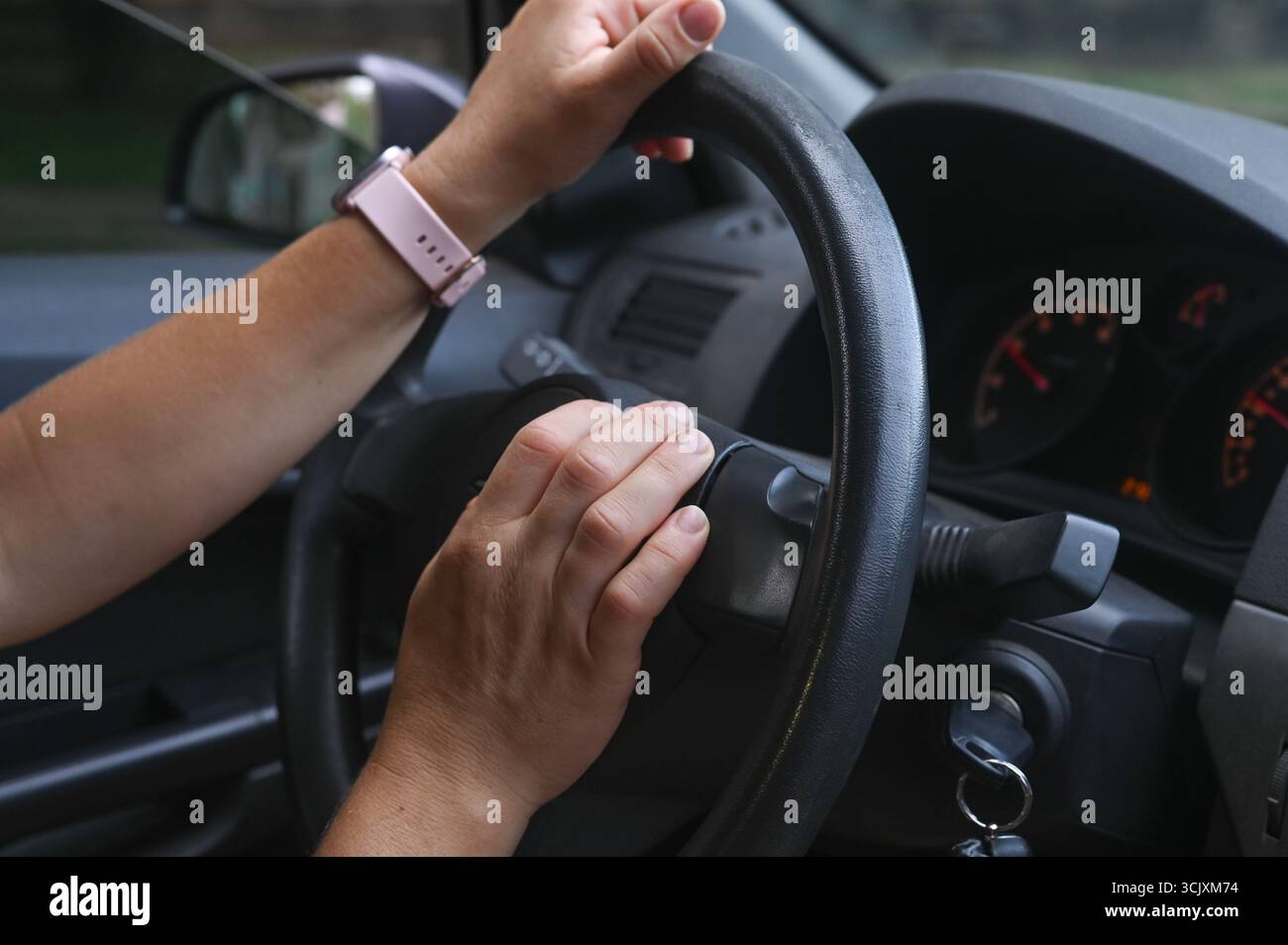 woman presses signal on steering wheel of car. hand grip steering wheel ...