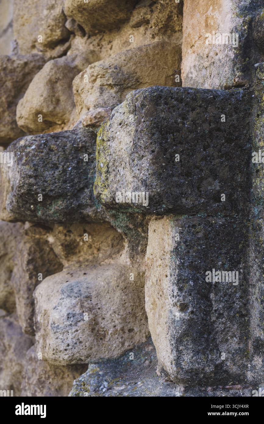 Rough textured surface of an old stone wall displaying the effects of ...