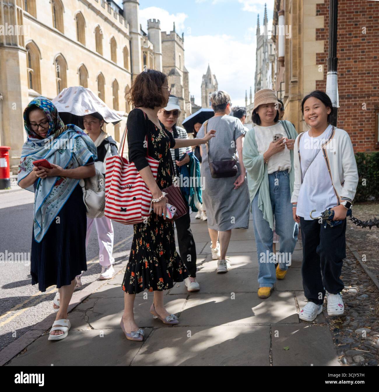Tourists explore historic Cambridge, England, with King's College Chapel in the background on a ...