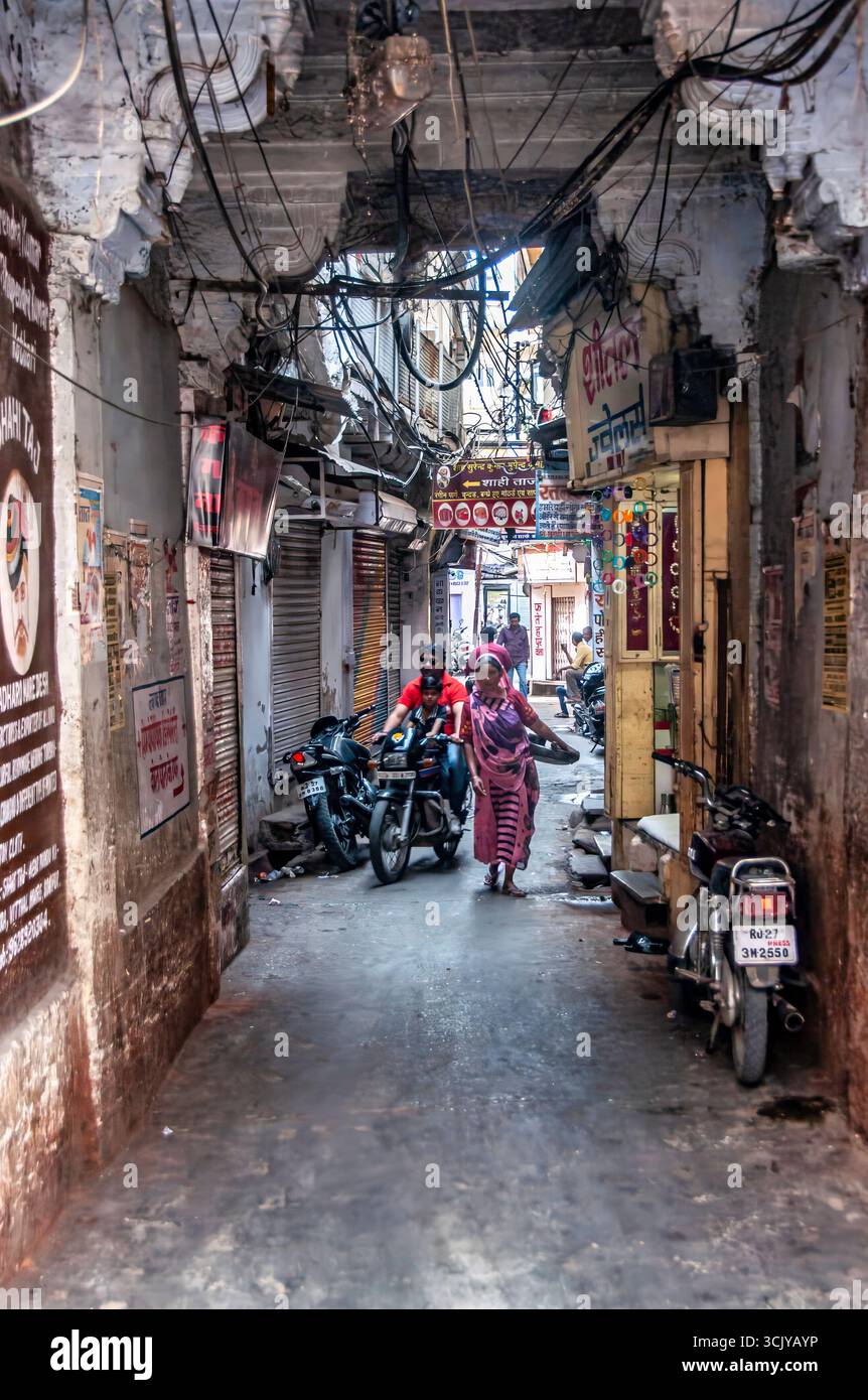 Woman passing by an archway. Scenes in the old city of Udaipur streets ...