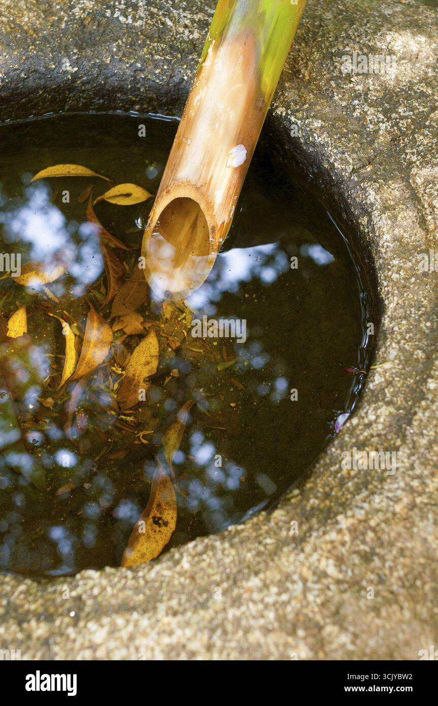 Traditional Japanese water basin Tsukubai fragment with bamboo pipe ...