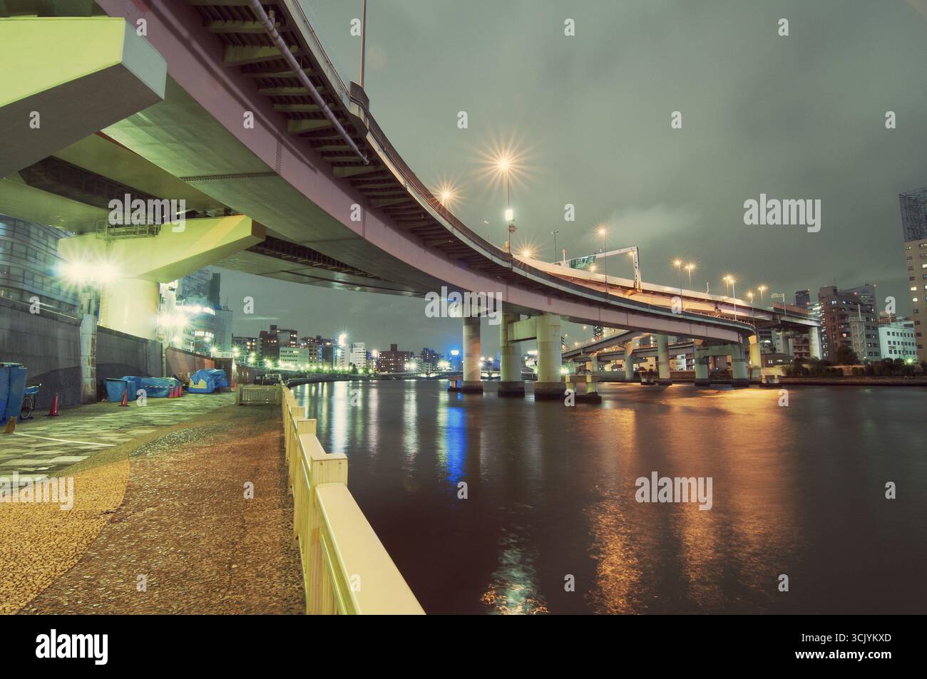 Empty embankment with hanged highway structure by night at Sumida river ...