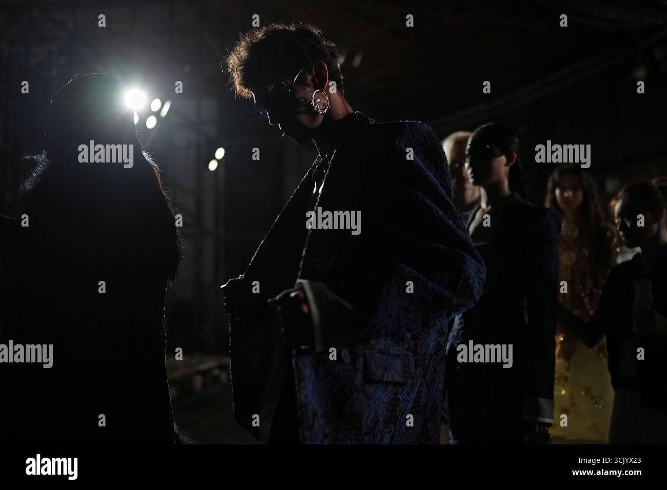 Models wait in line in the backstage to present a creation by Maggie Ma ...