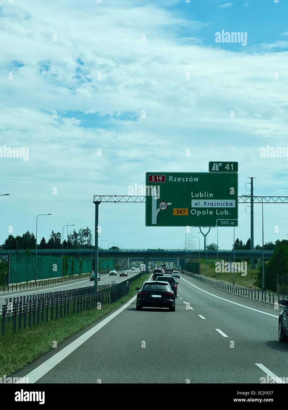 Road view with traffic, directional signs, and a vibrant sky Stock ...