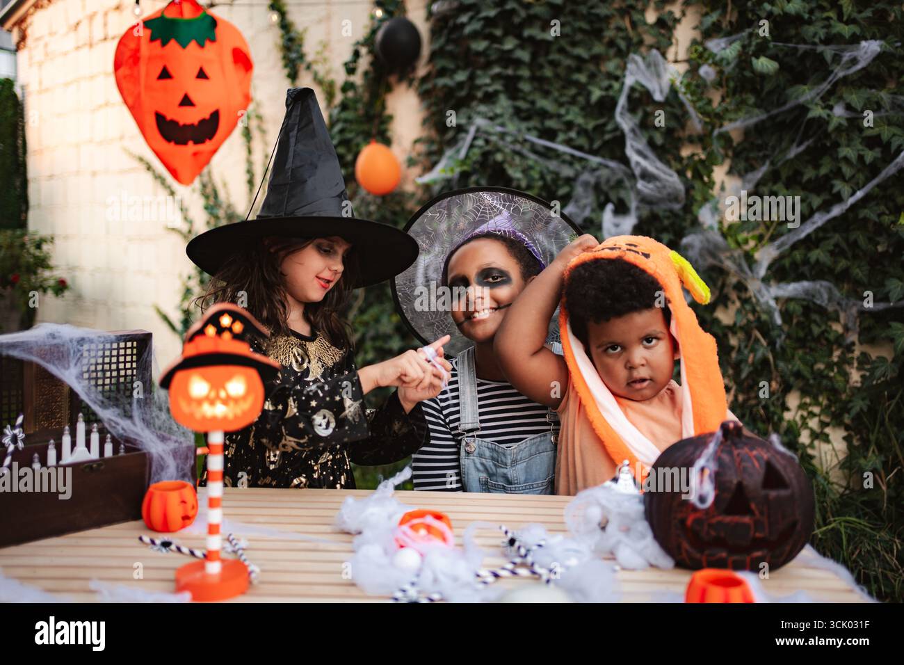 Children wearing Halloween costumes preparing for a masquerade ball ...