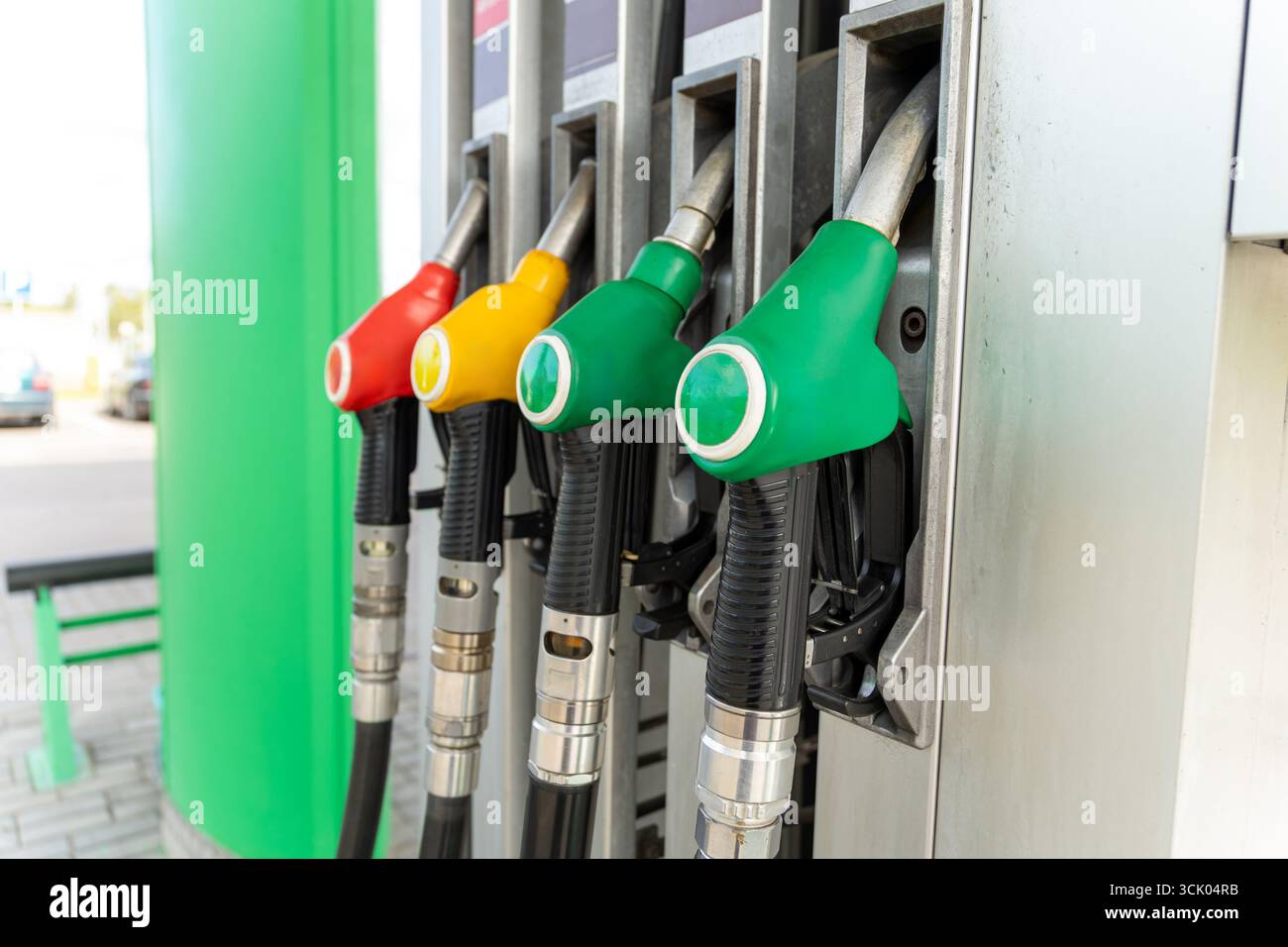 Close-up of four fuel dispensing nozzles on a gas pump, ready for ...