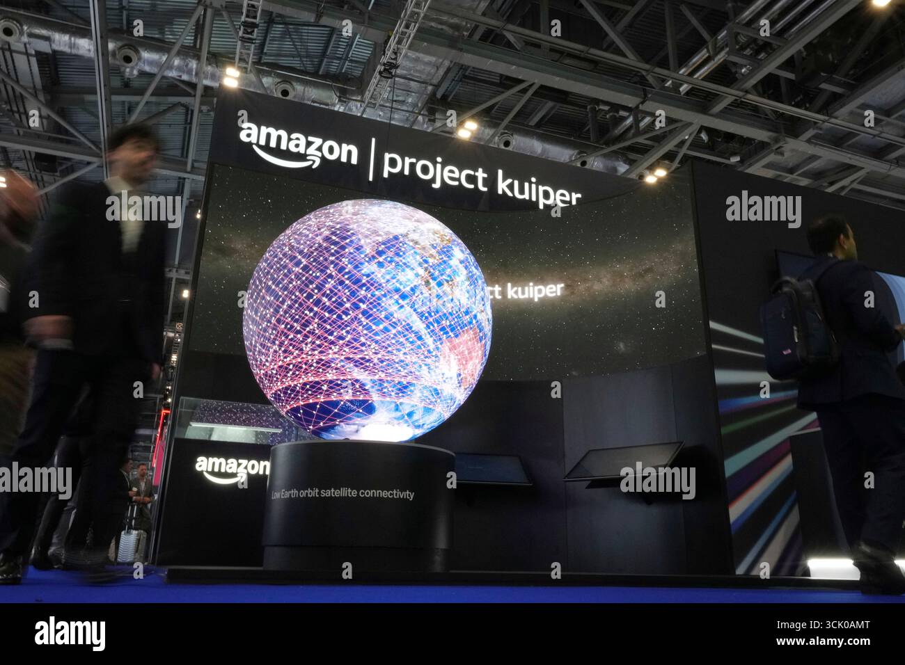 Visitors walk past the Amazon project Kuiper, low orbit satellite ...