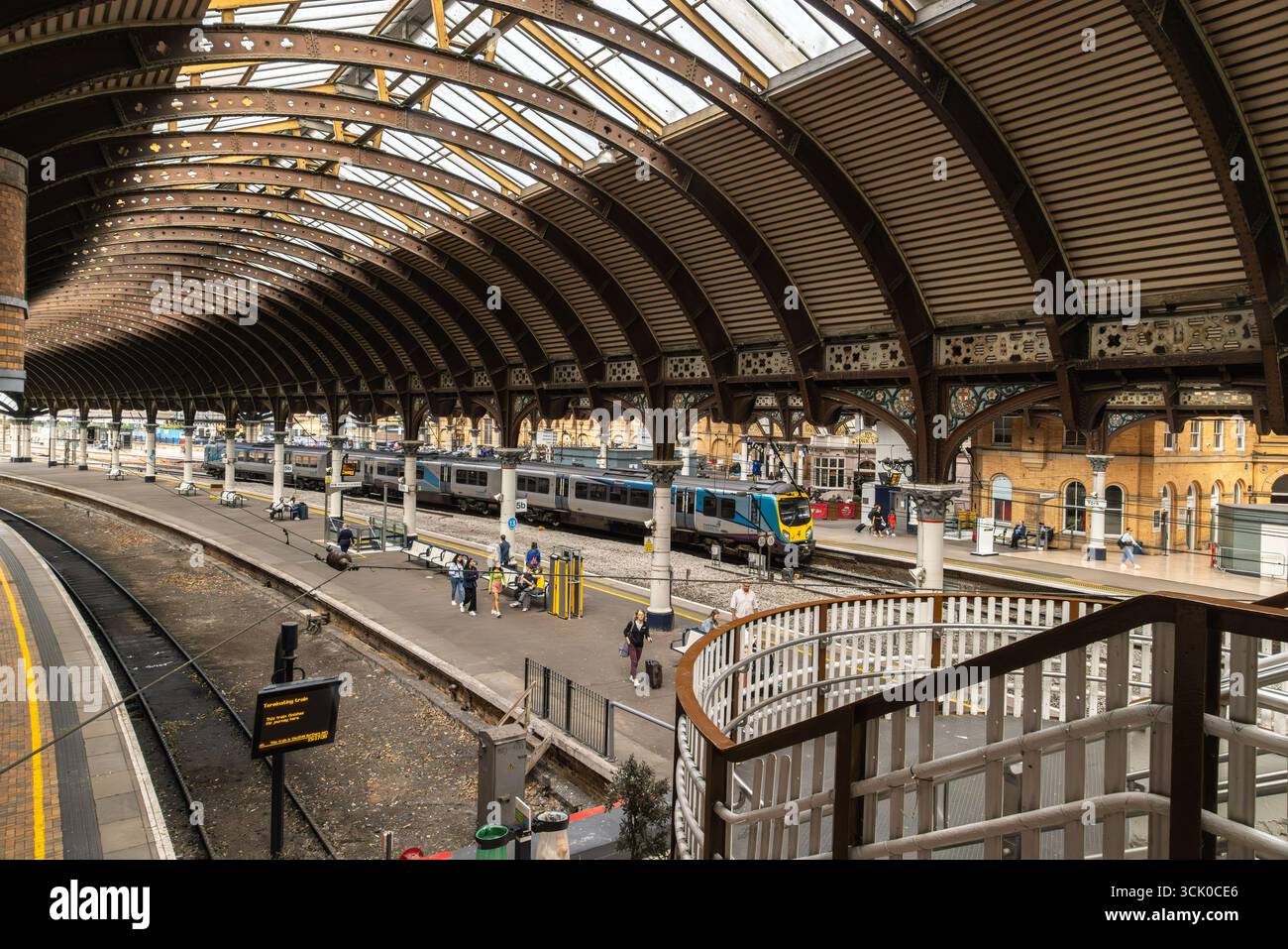 Passengers move through York railway station, beneath vaulted glass ...