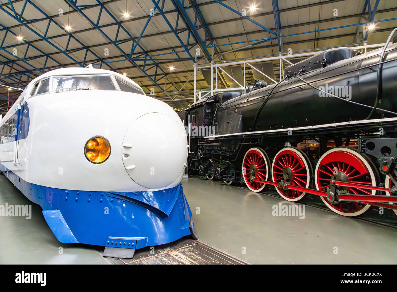 A modern high speed train prototype beside a classic steam locomotive ...