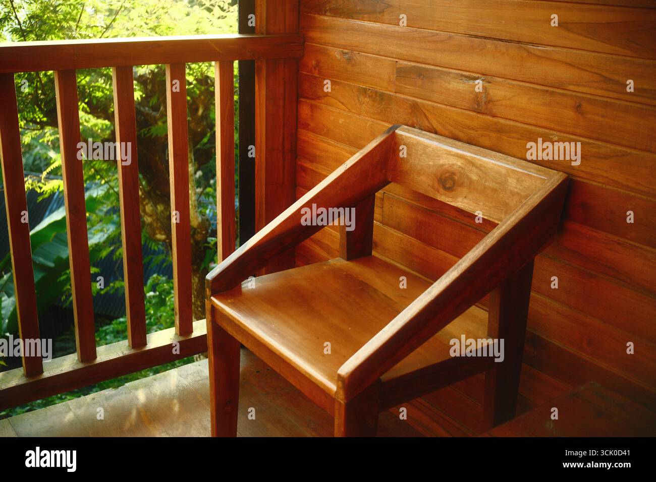 A solid wooden chair on a balcony terrace Stock Photo - Alamy