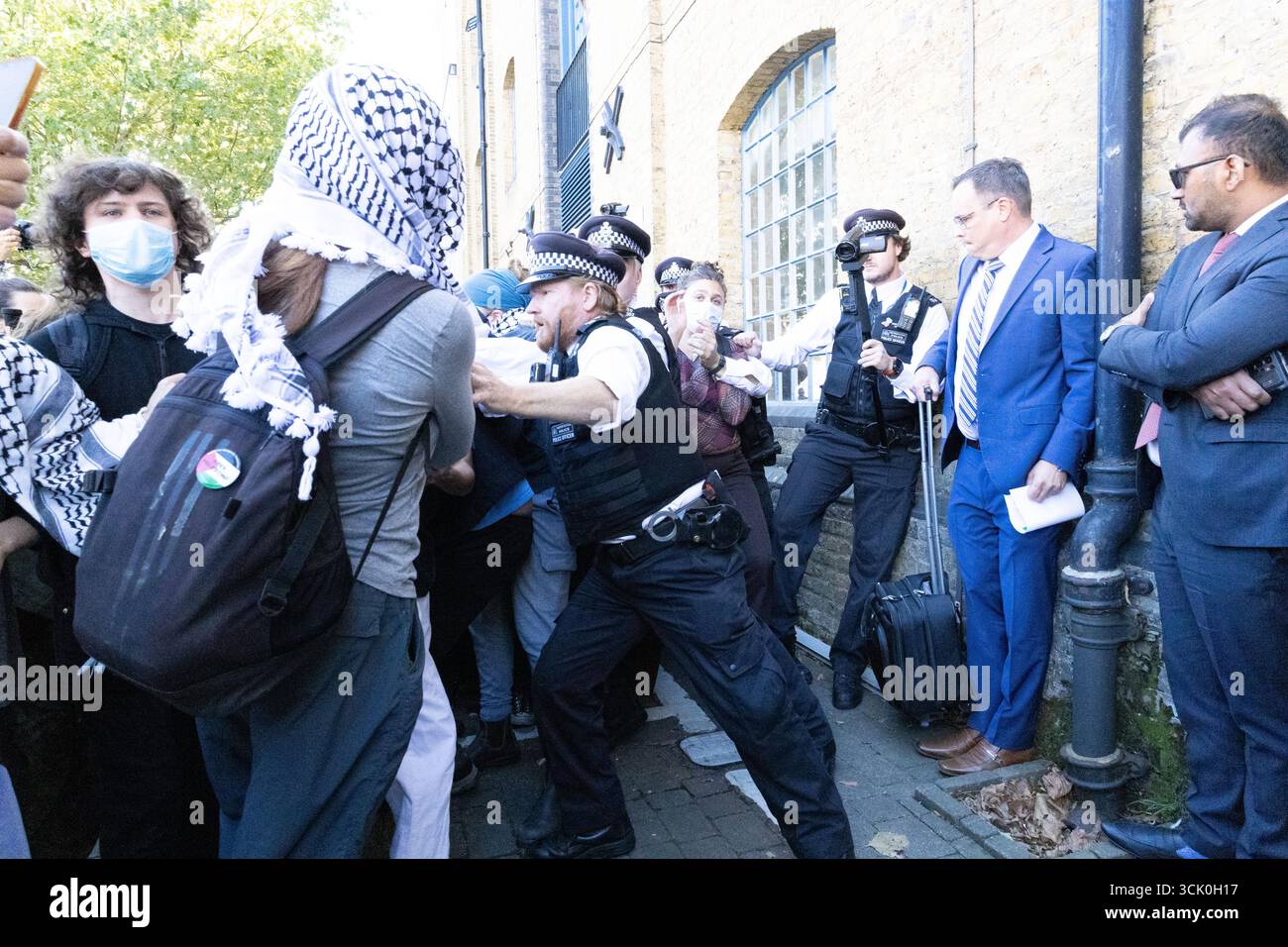 Police push back protesters to create a cordon for delegates at the ...