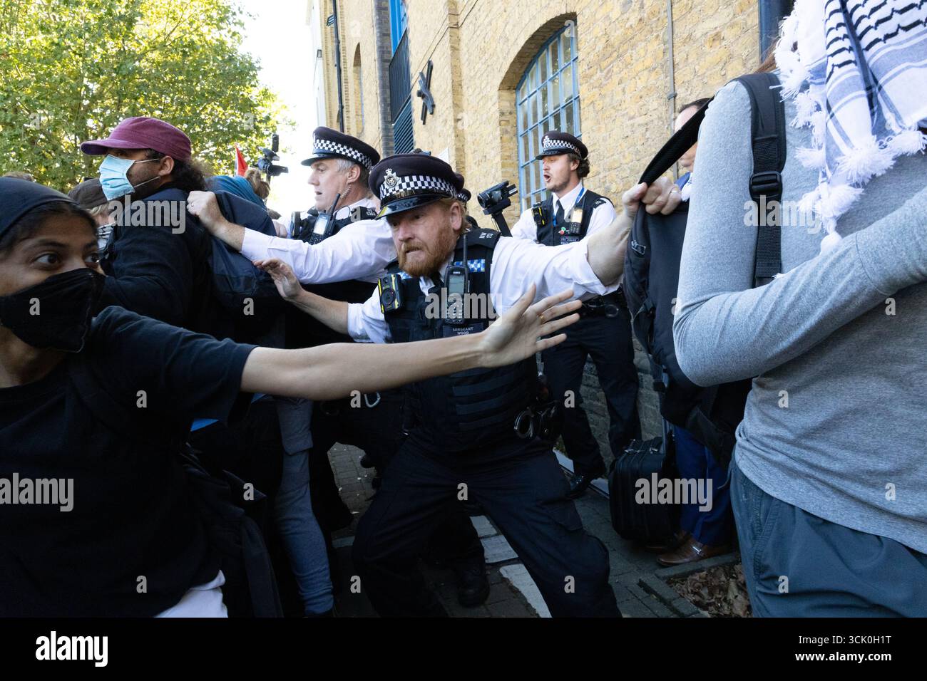 Police push back protesters to create a cordon for delegates at the ...