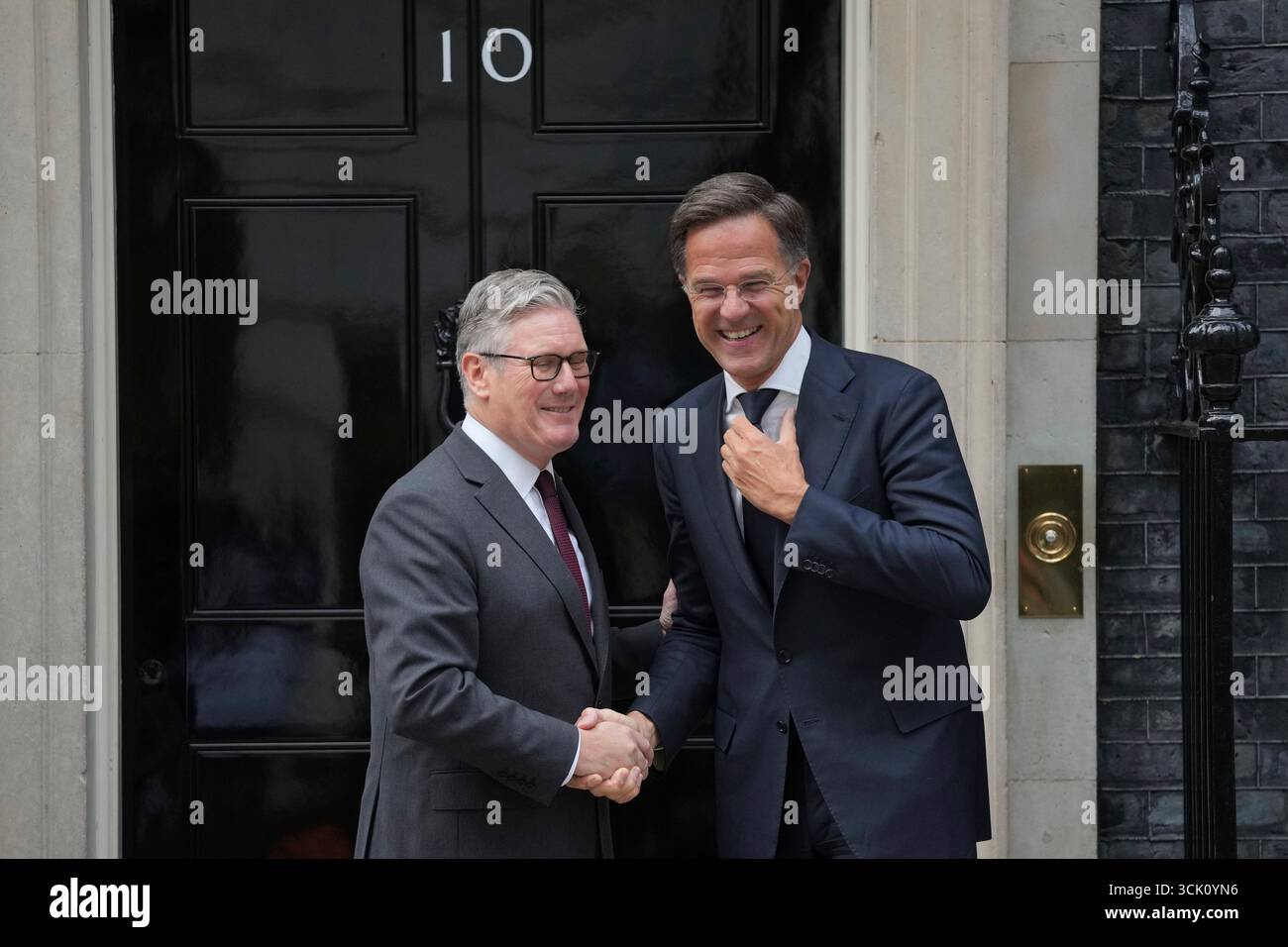 Britain's Prime Minister Keir Starmer, left, shakes hands with NATO ...