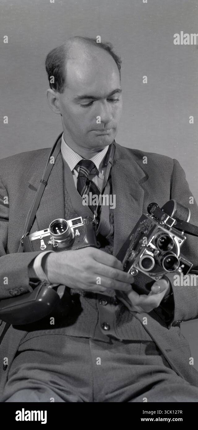 1950s, historical, photographer and cameraman, a suited gentleman with ...