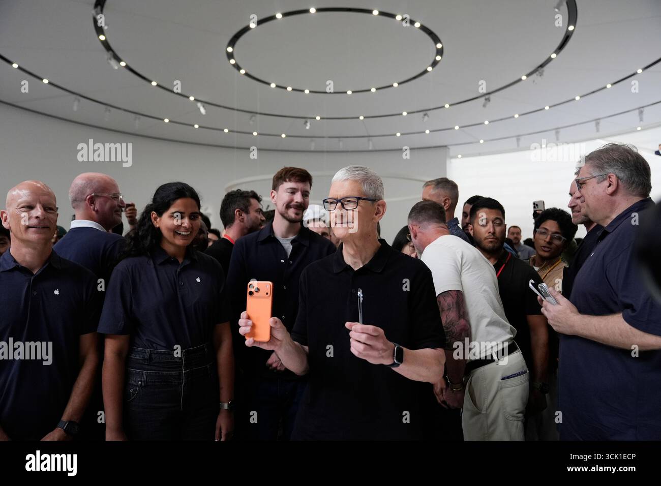 Apple CEO Tim Cook holds new iPhones during an announcement of new ...