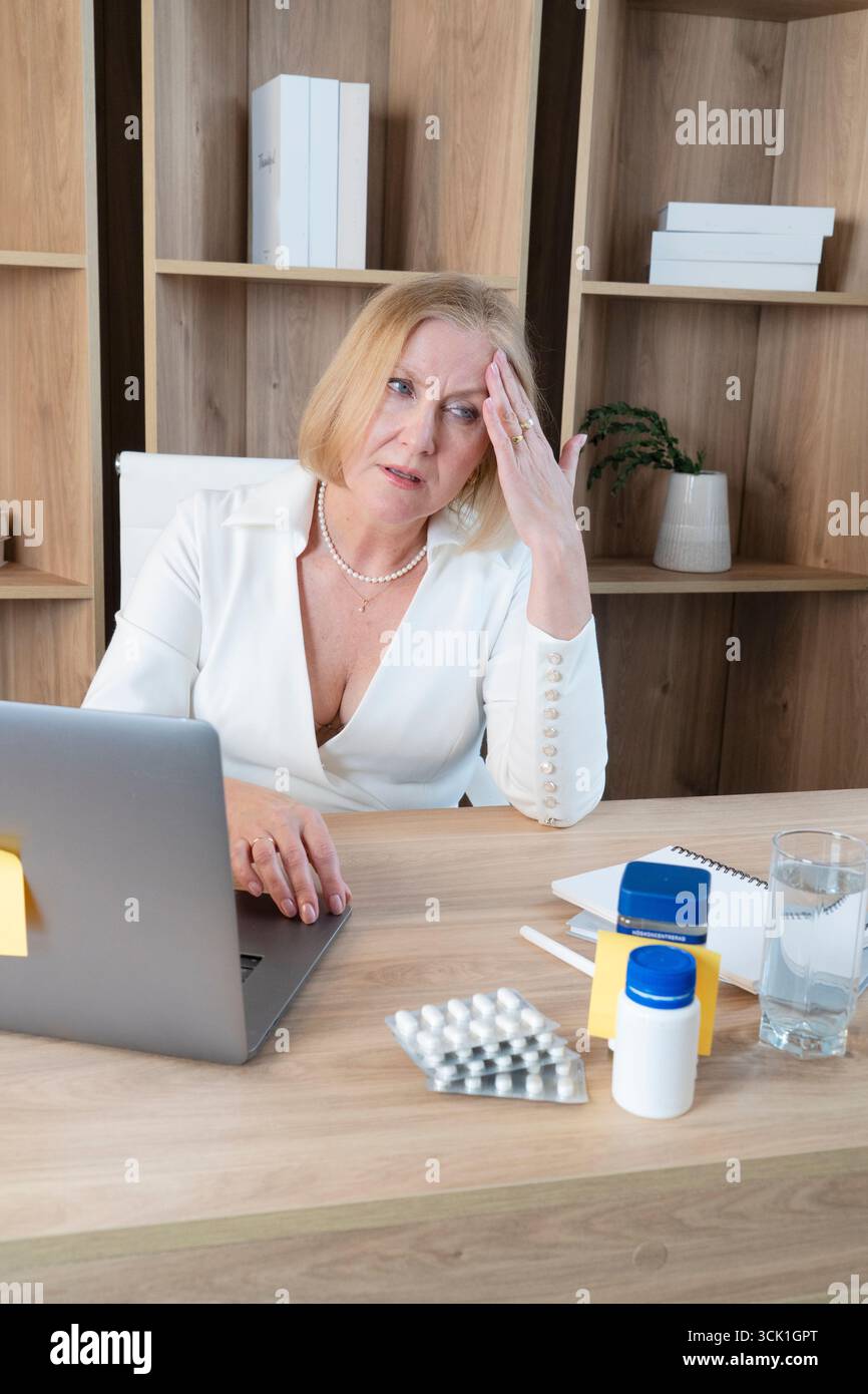 A Stressed Woman with Her Medication at Her Home Office While Managing ...
